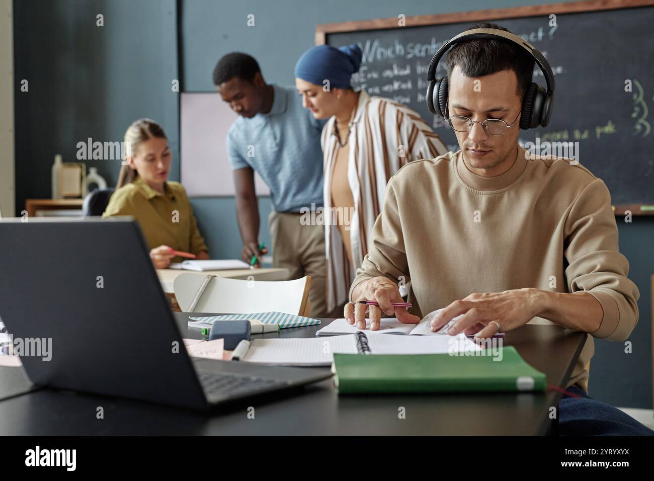 Medium shot of concentrated multiracial man in headphones completing ...