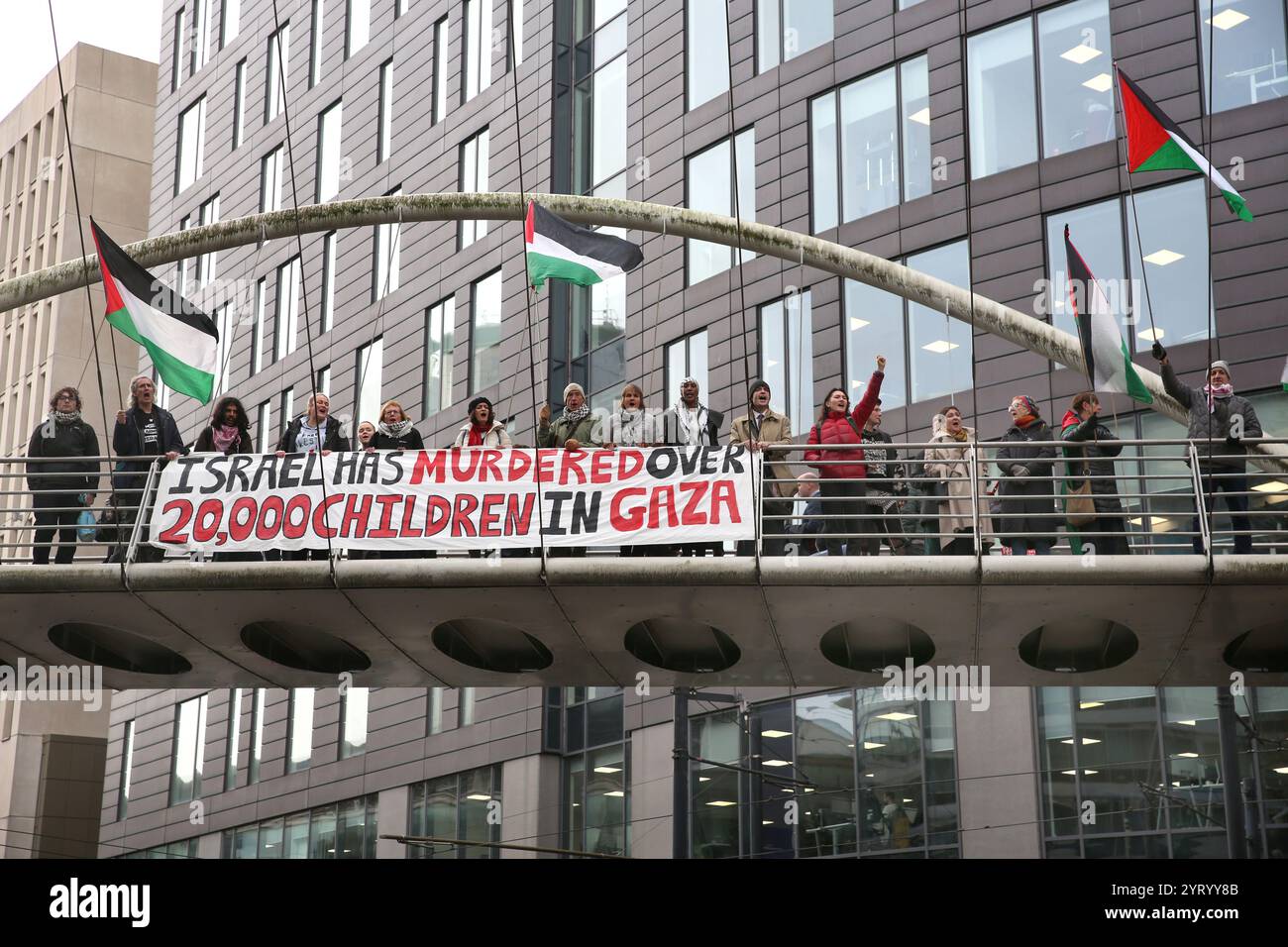 Protesters hold a banner saying “Israel Has Murdered Over 20,000 ...