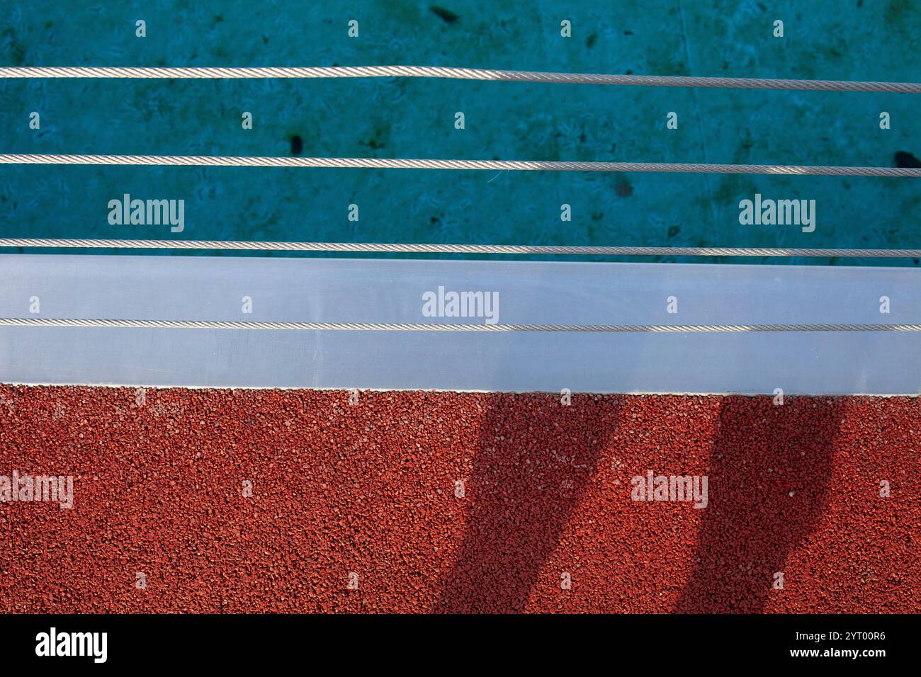 Standing on the red rubber floor near the edge of the public swimming ...