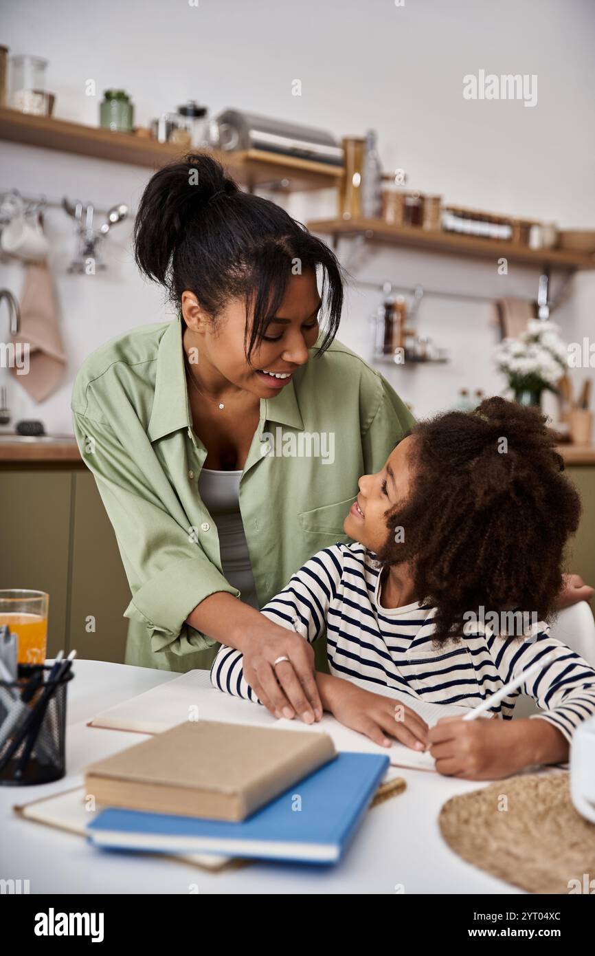 Mother helps her daughter with an art project while sharing laughter ...