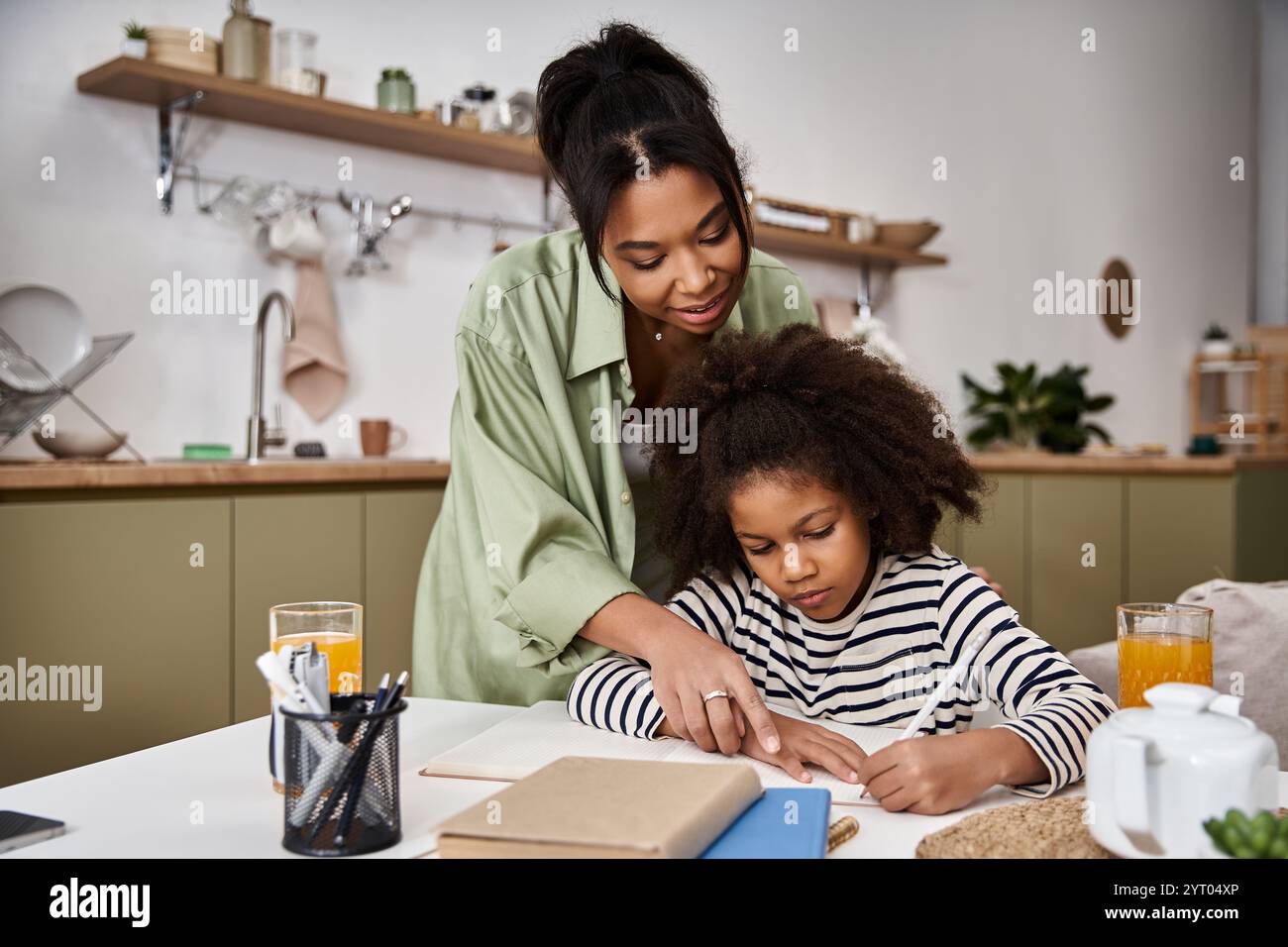 A loving mother guides her daughter in an engaging activity, fostering ...