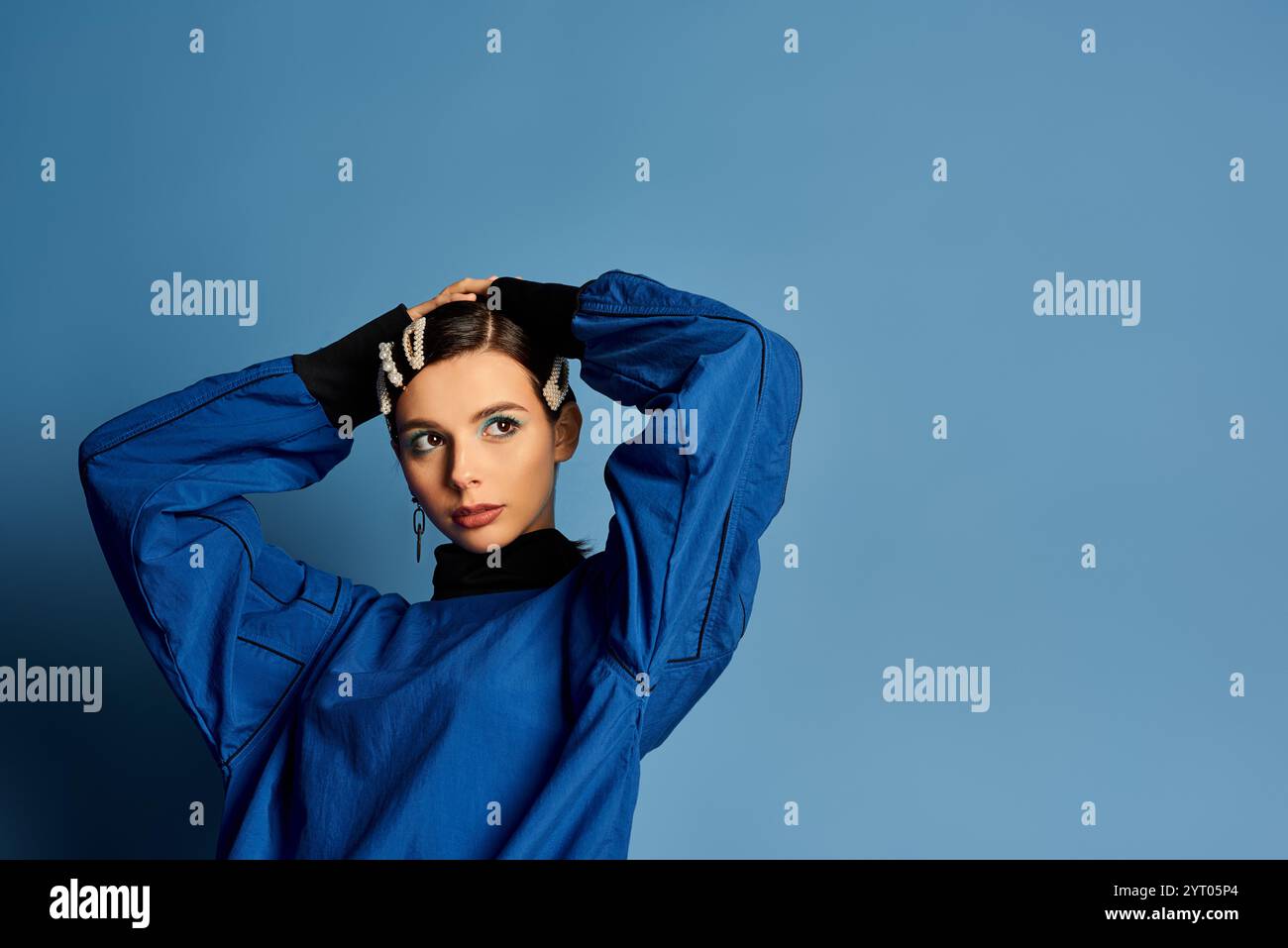 A young woman poses elegantly in trendy attire and hair clips in a ...