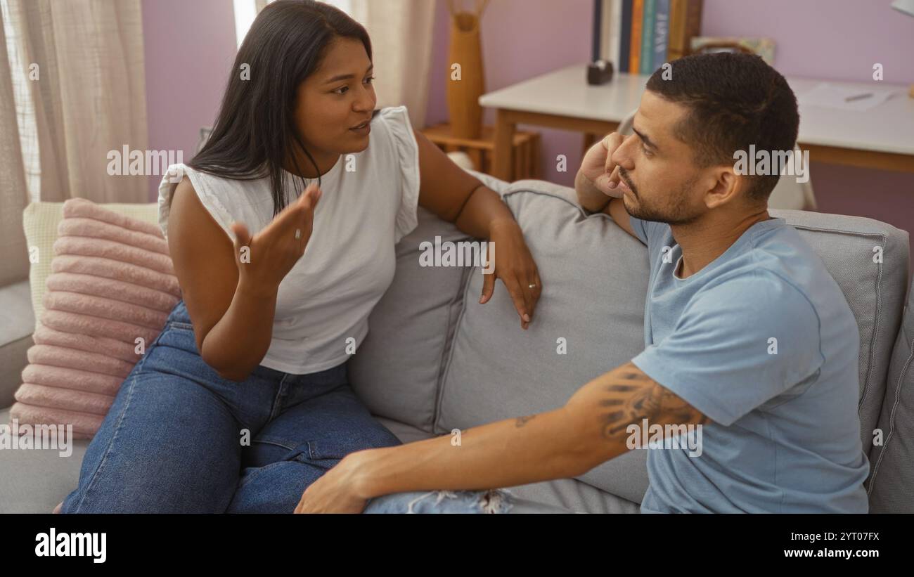 Hispanic couple sitting together in a cozy living room engaged in a ...