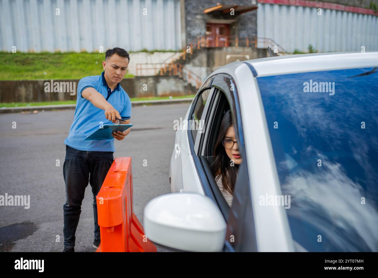 A Parking Attendant is Providing Assistance to a Driver at the Entry ...