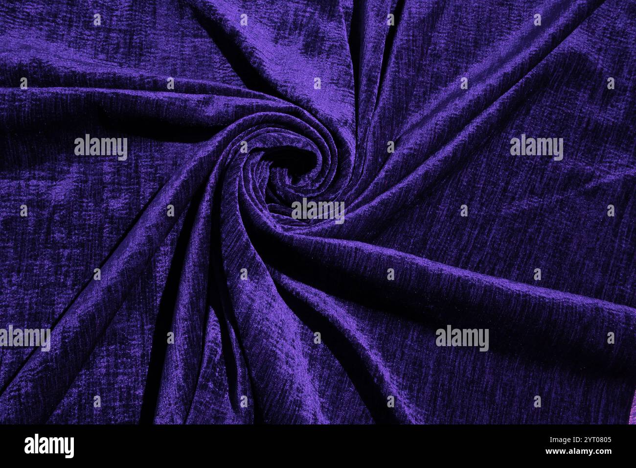 soft folds of velvet fabric of dark blue color, twisted in a spiral ...