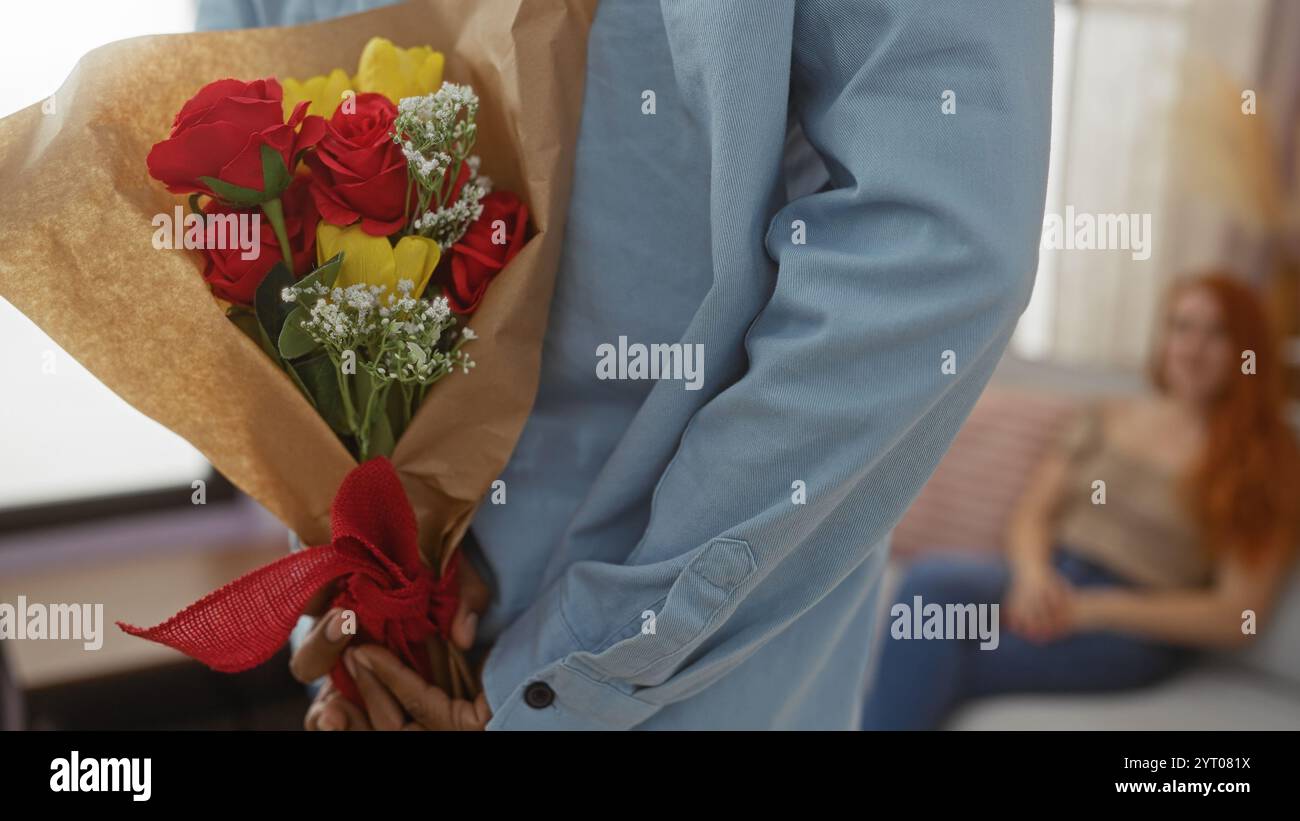 Man holding bouquet of flowers behind back while woman sitting on couch ...