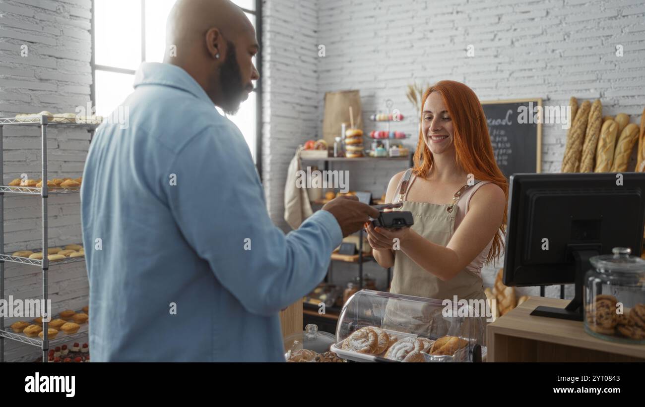 Man and woman standing together in an indoor bakery, where the worker ...