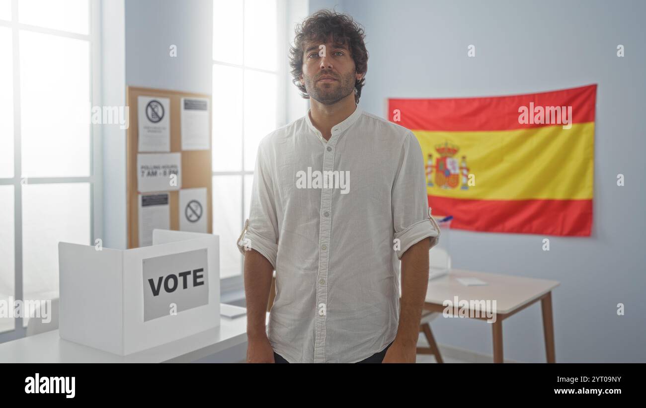 Young man standing in a spanish electoral room with a voting booth and ...