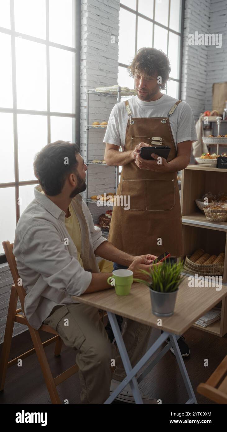 Two men interacting in a bakery with a waiter taking an order from a ...