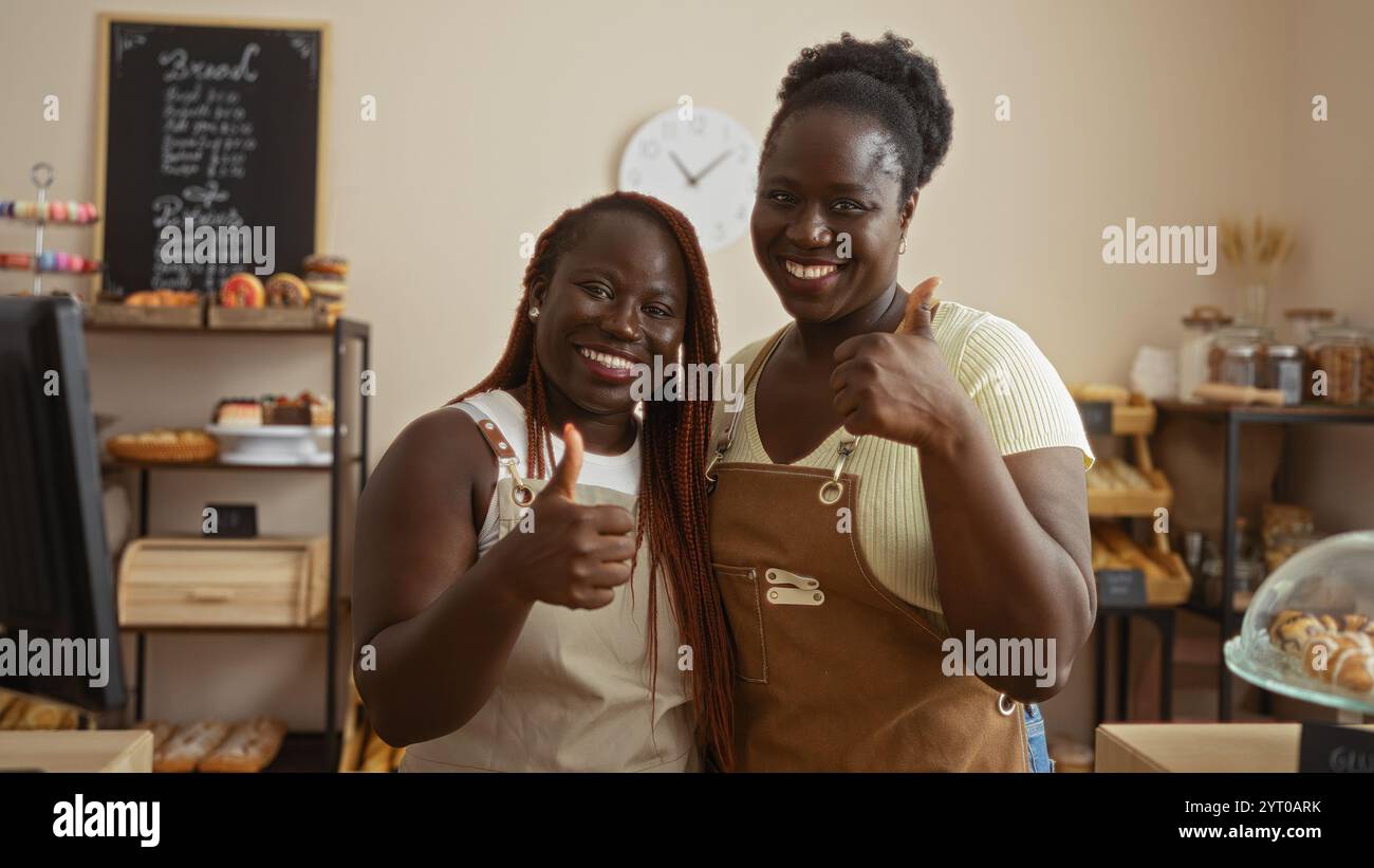 African american women bakers smiling and giving thumbs up in a cozy ...