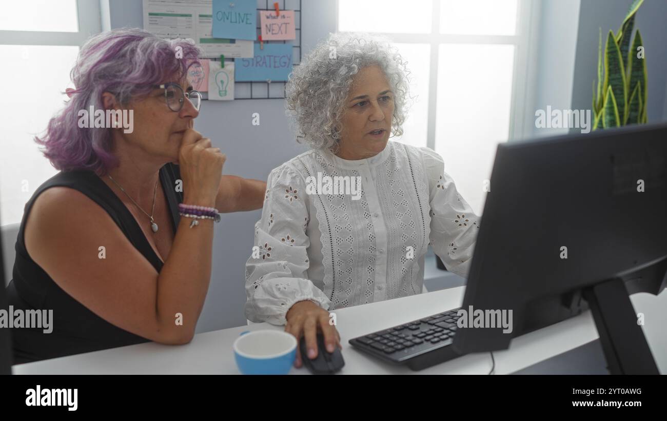 Middle-aged women collaborating in an office setting, intensely focused ...