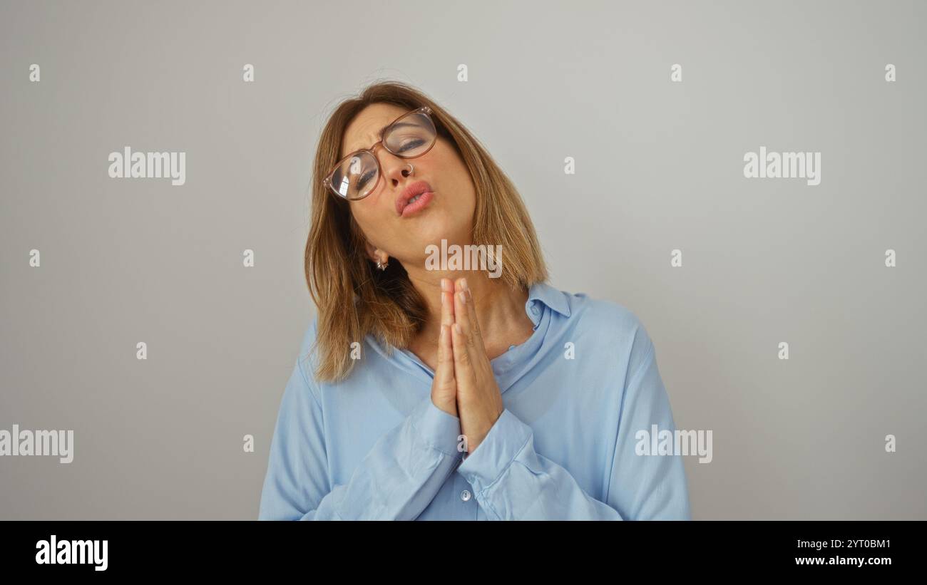 Woman praying looks emotional over an isolated white background ...