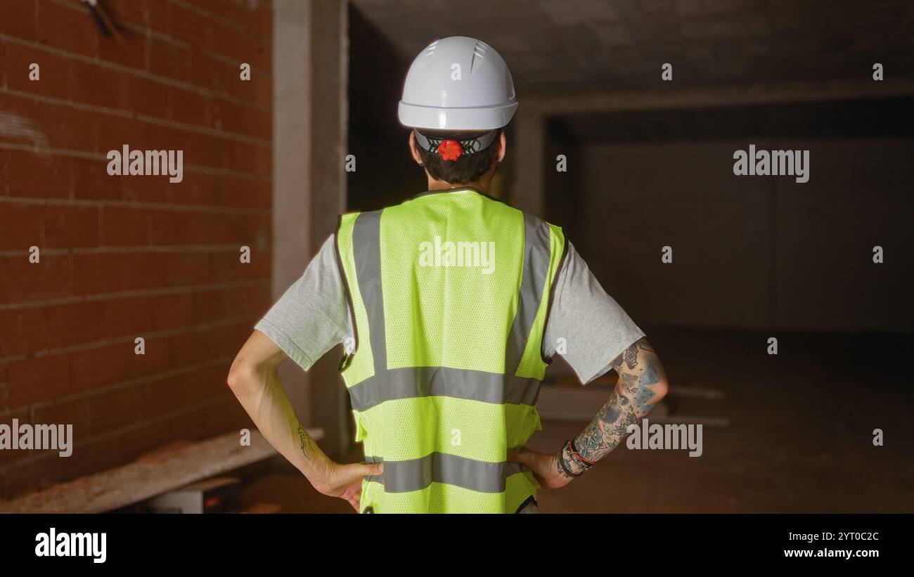 Young man in safety vest and helmet at construction site inspecting ...