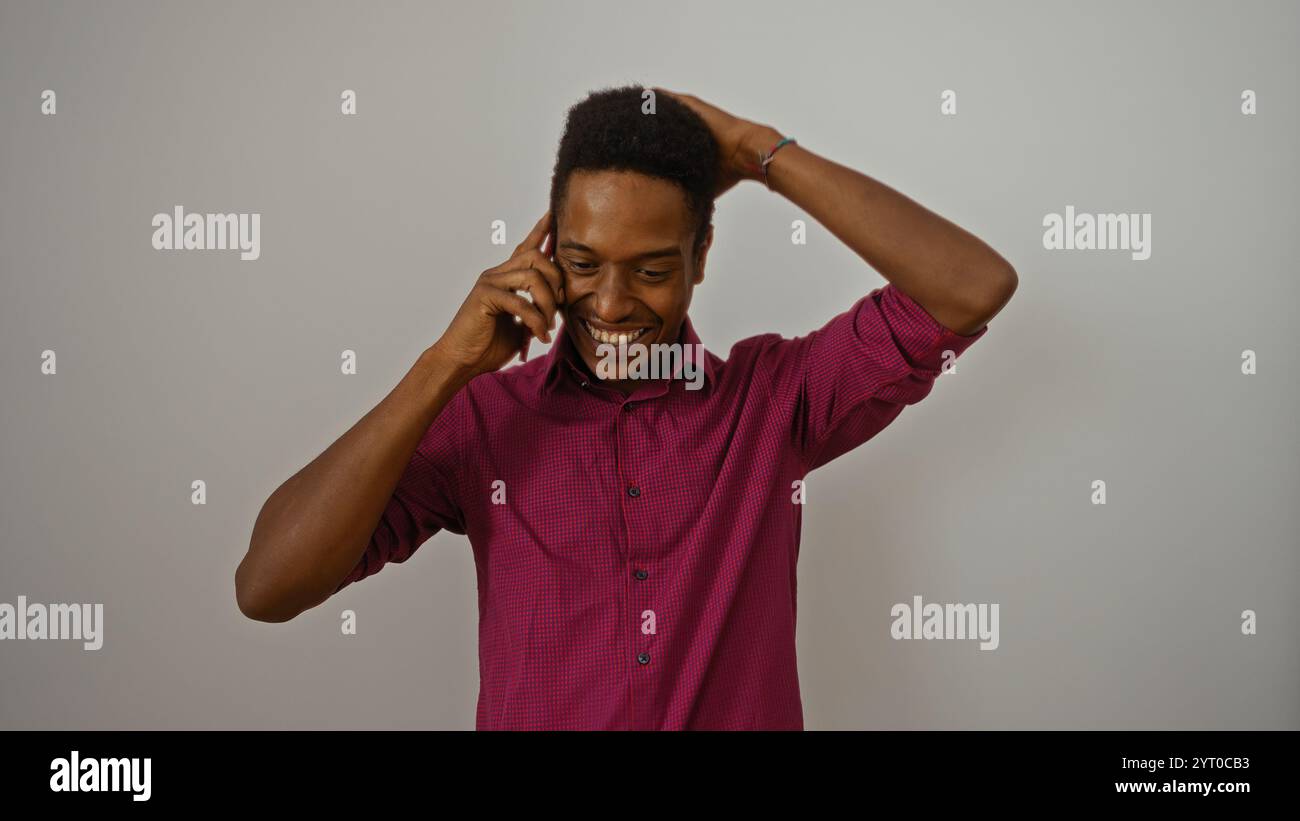 Man smiling talking on smartphone against white background wearing pink ...