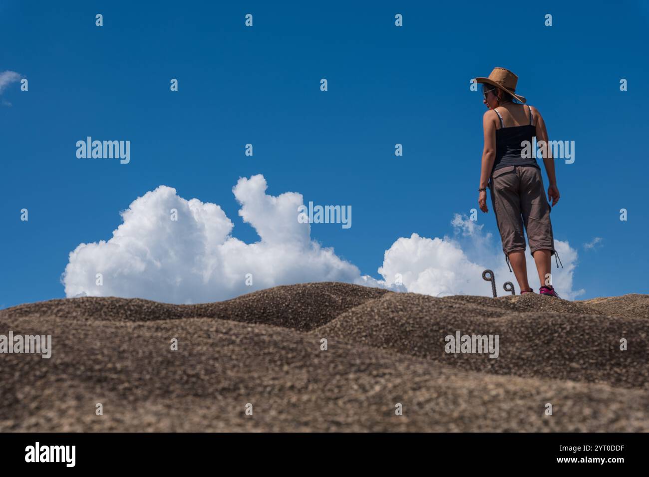 A traveler looks out over the landscape from atop a rock in the ...
