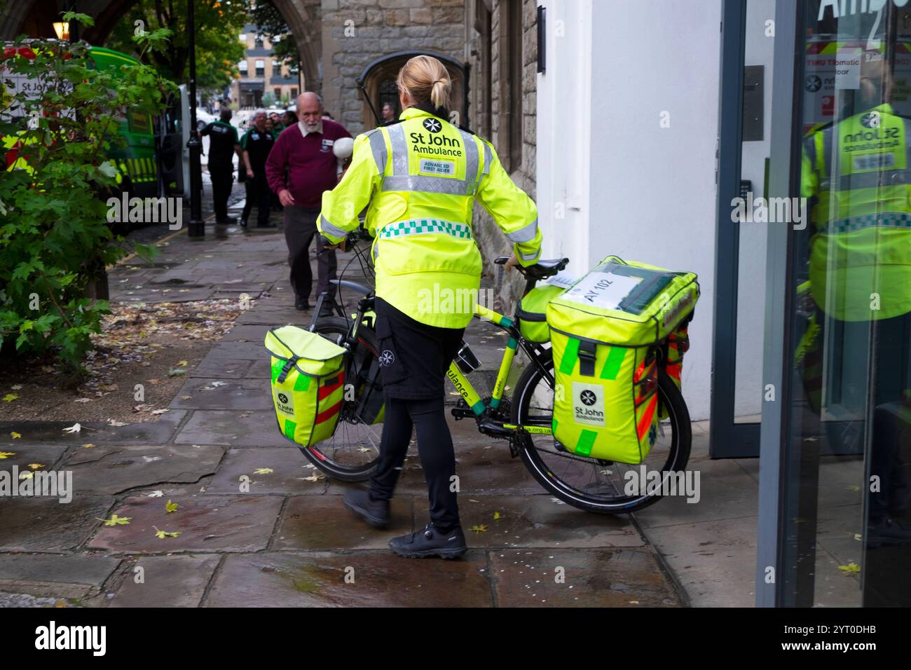 Rear back view of woman worker wearing St John ambulance fluorescent ...