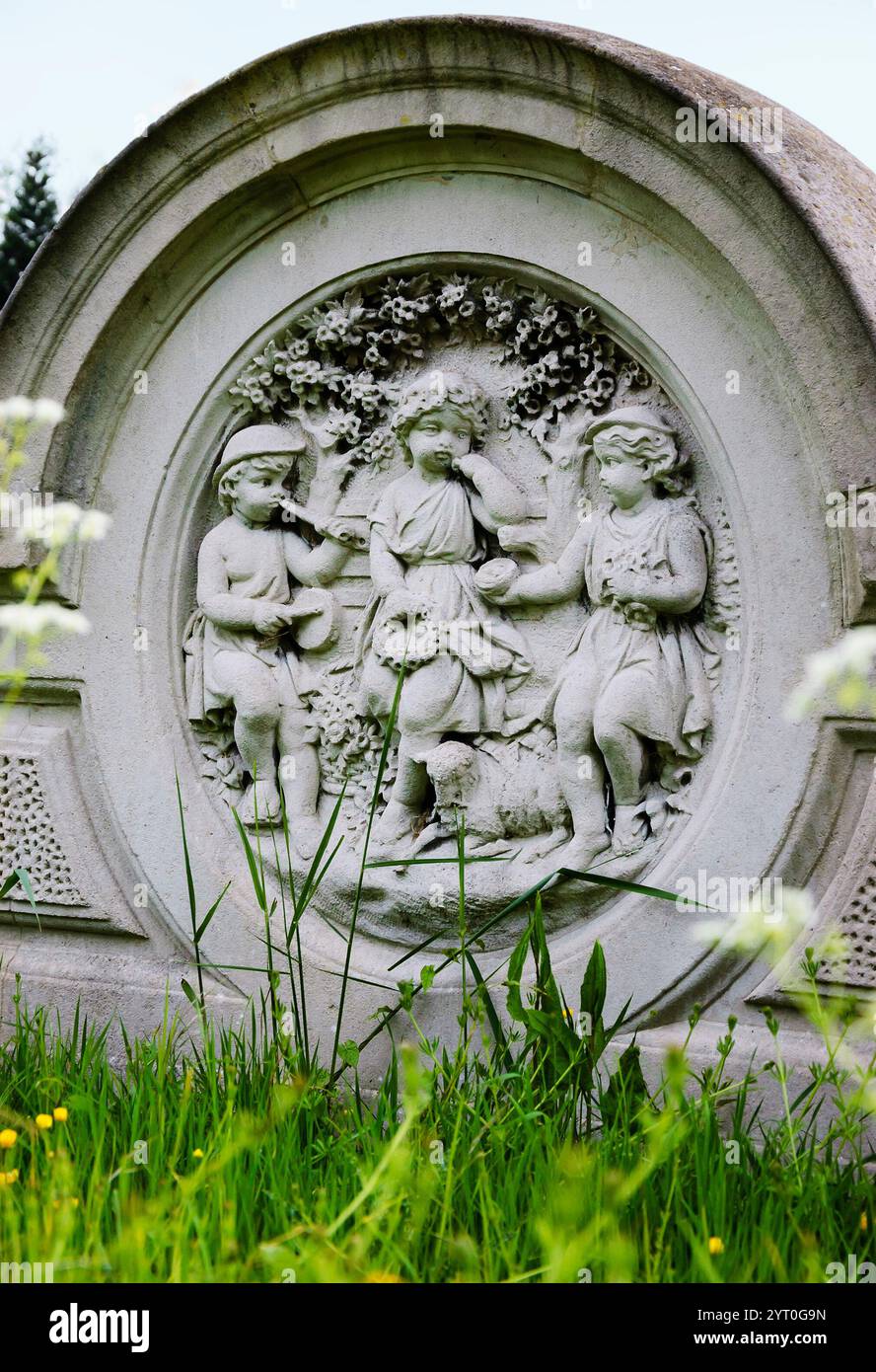 Park sculpture. Idyllic scene on bas-relief: A boy (Pan) with pipes and ...