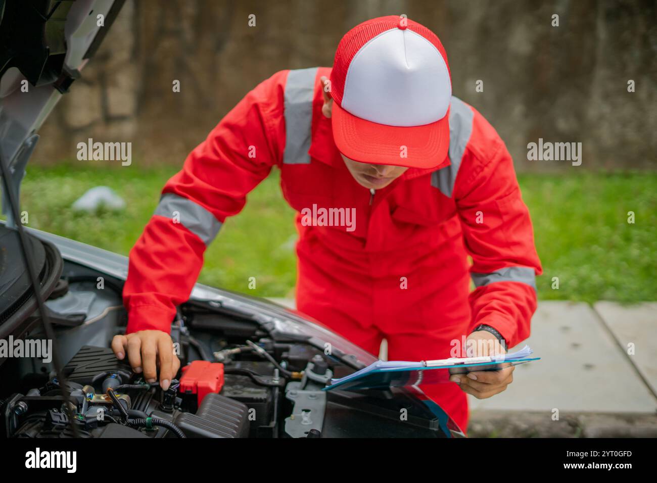 A skilled mechanic is inspecting the car engine for troubleshooting and ...