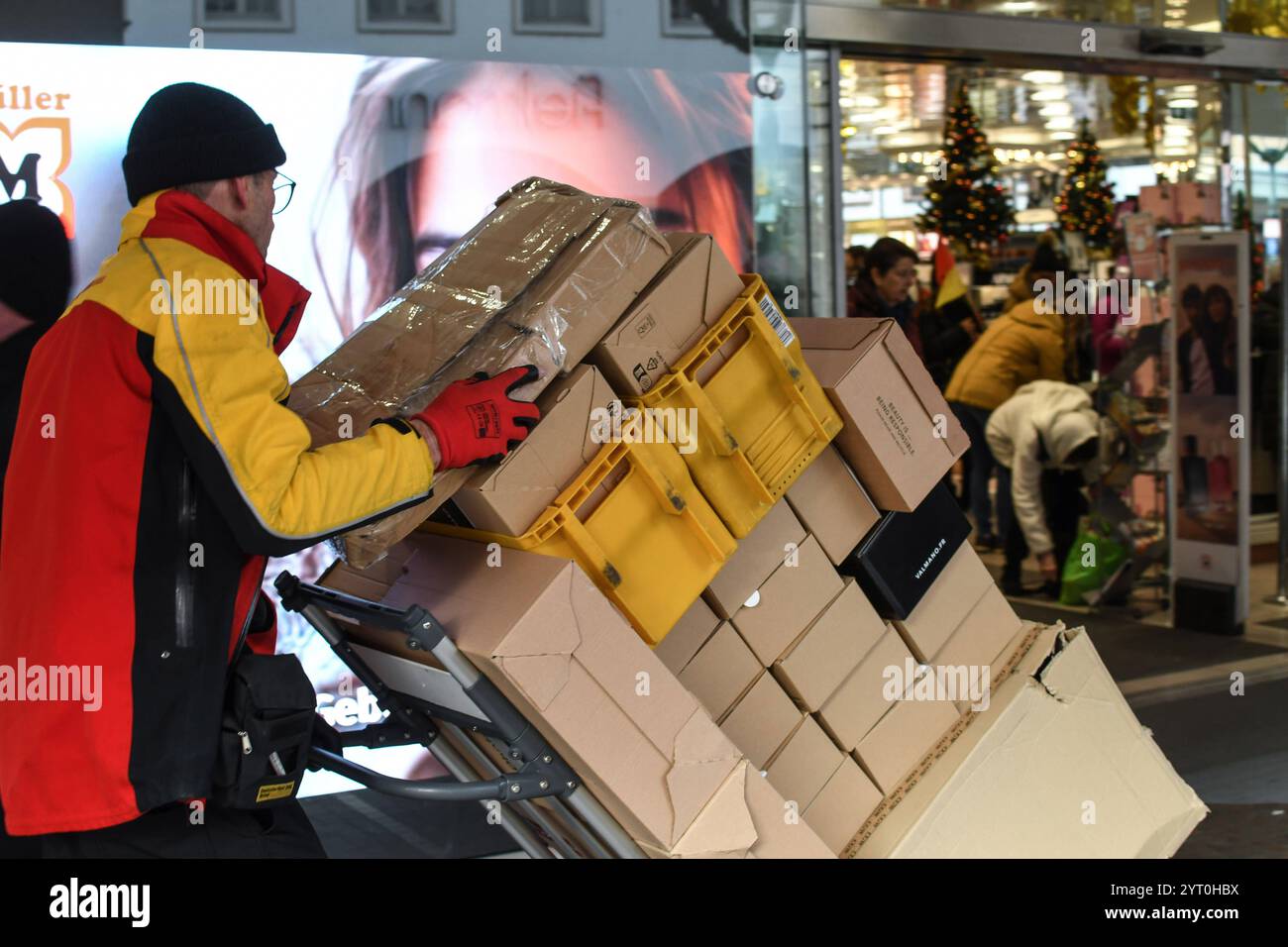 Paketbote liefert einen Berg von Paketen aus. *** Parcel carrier ...