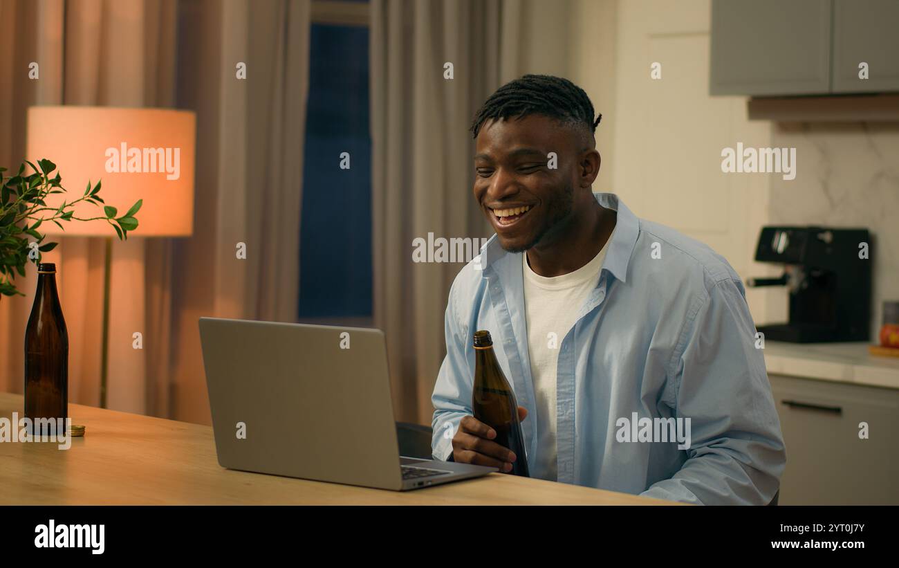 Happy success achieve glad African American man at table kitchen drunk ...