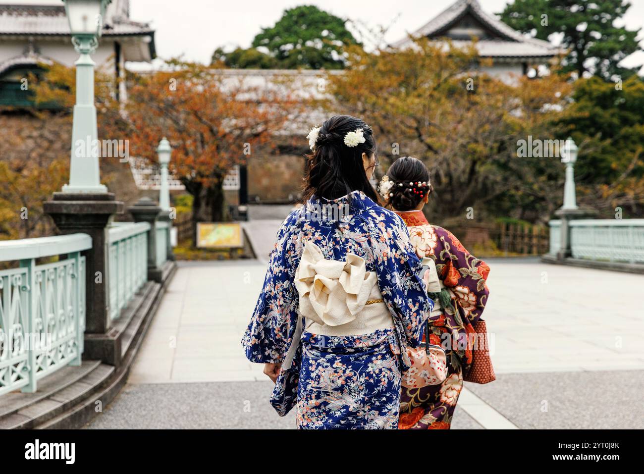 Two women dressed in vibrant and colorful kimonos leisurely stroll ...