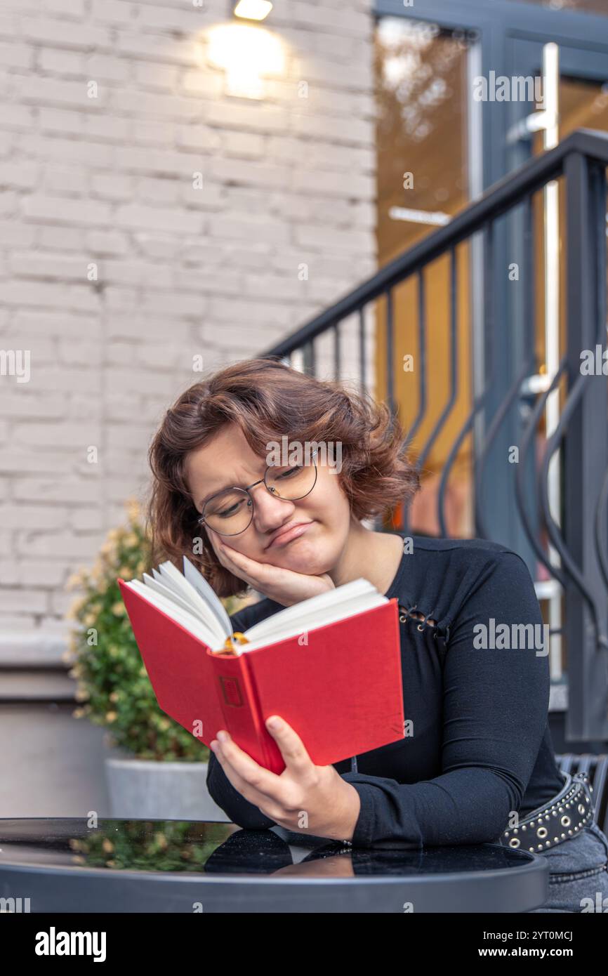 Tired and sleepy young woman reading a book. Emotion concept Stock ...