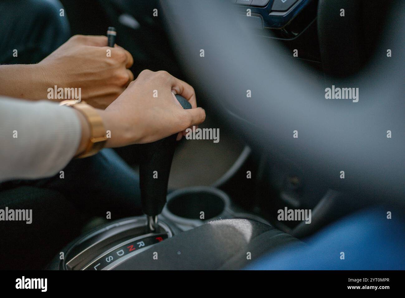 Hands gripping the gear shift in a car, highlighting the thrilling ...