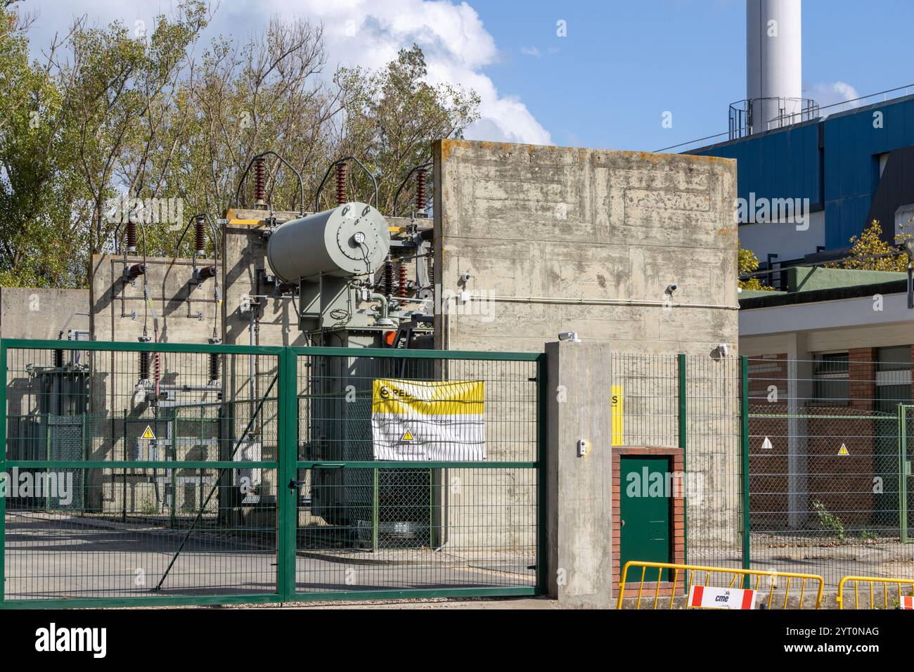 Electrical substation with transformer and warning sign behind a ...