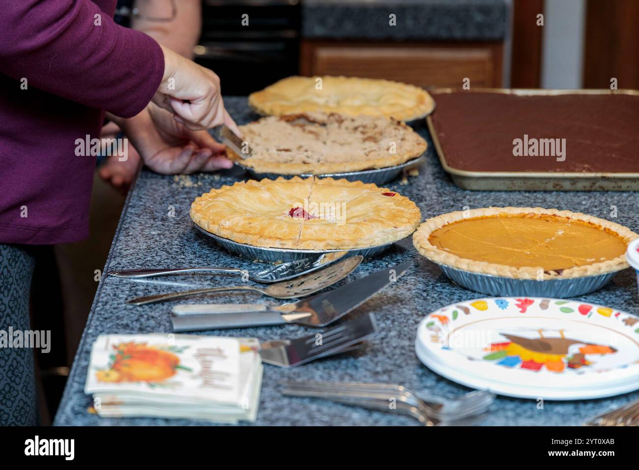 slicing the Thanksgiving Day pie selections to begin serving them Stock Photo - Alamy