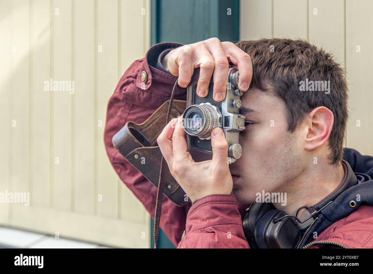 A young man takes pictures on a vintage camera. Film camera photography ...