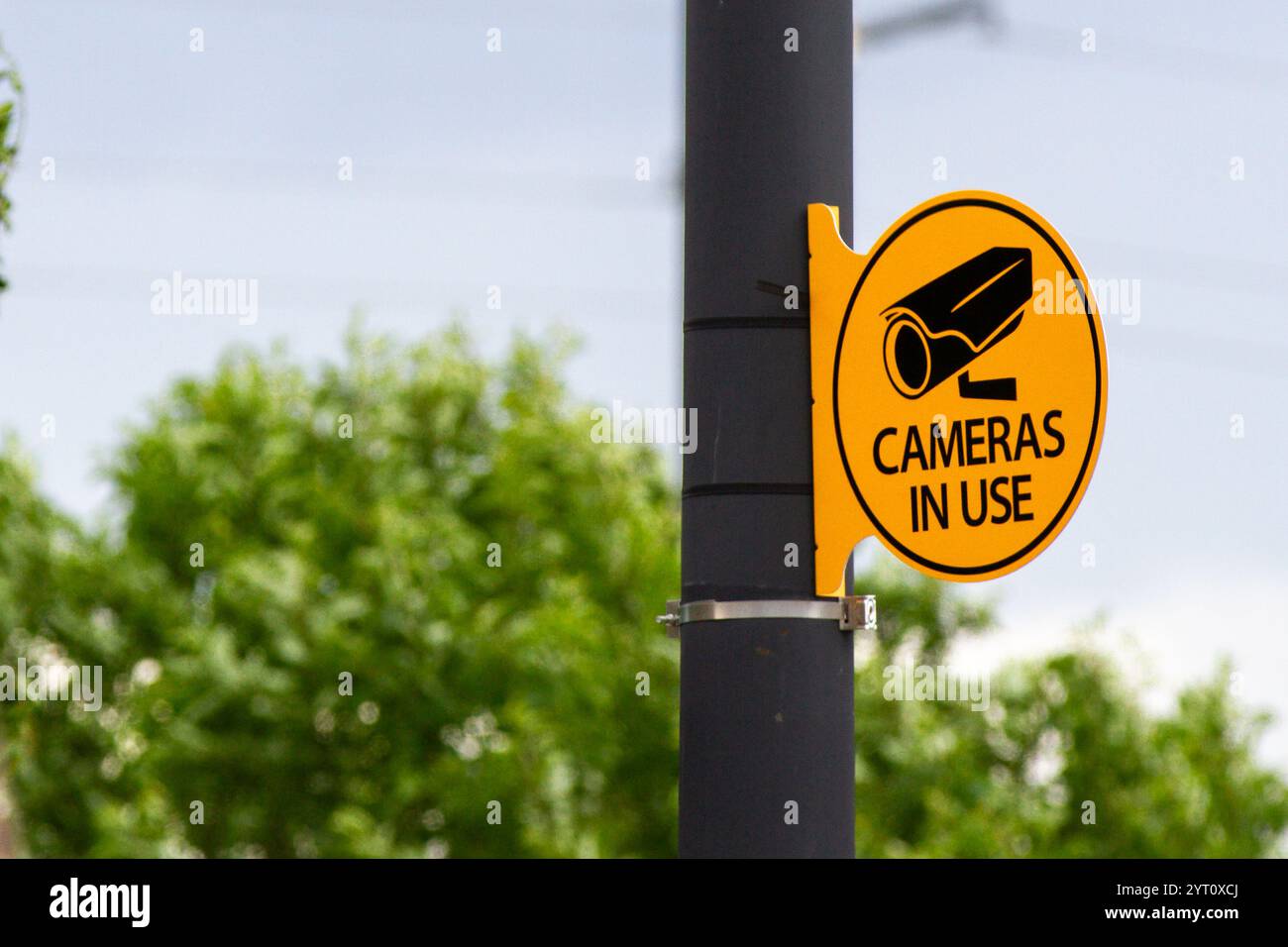 A pole with a sign on it that says "Cameras in use Stock Photo - Alamy
