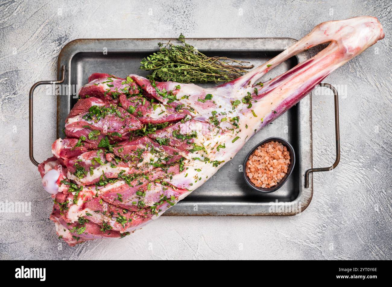 Marinated with herbs and olive oil raw goat leg. white background. top ...