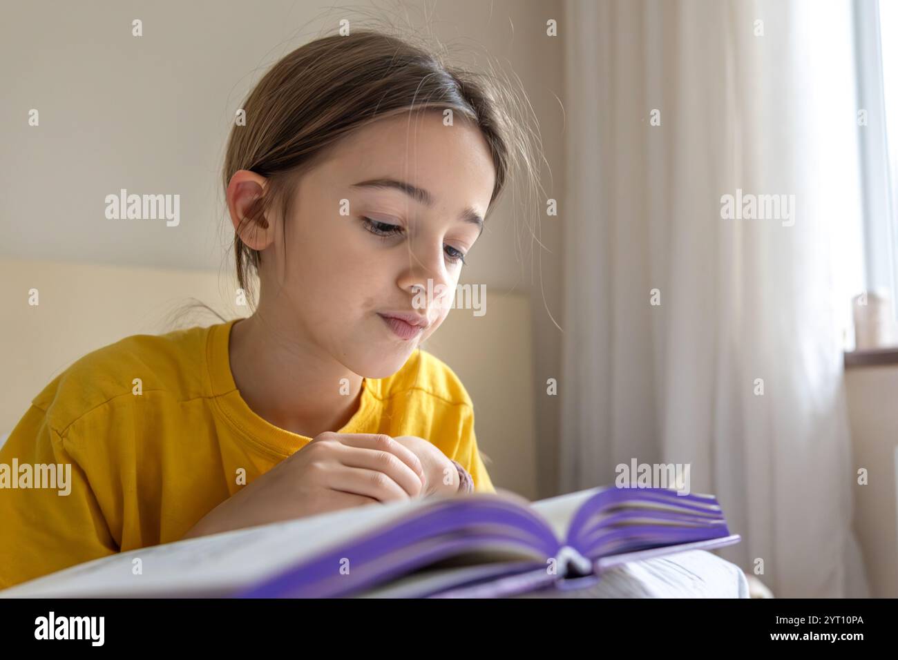 An interested and focused girl is reading a book. Emotion concept Stock ...