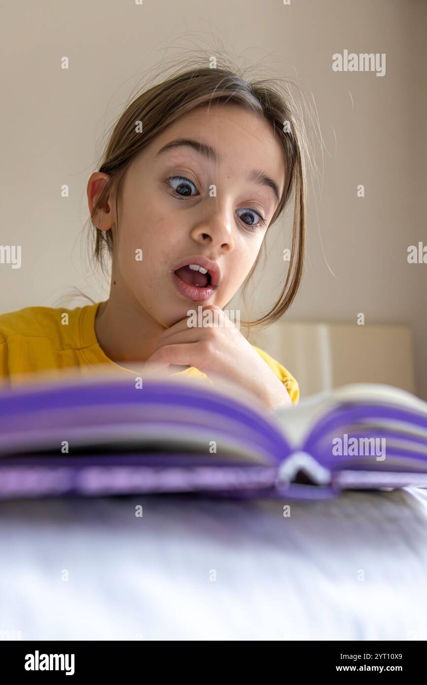 An interested and focused girl is reading a book. Emotion concept Stock ...