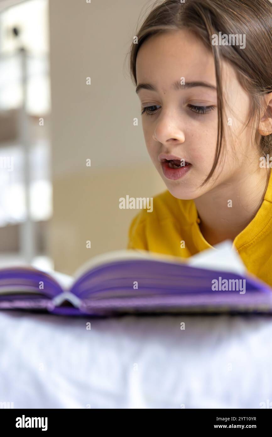 An interested and happy girl is reading a book. Emotion concept Stock ...