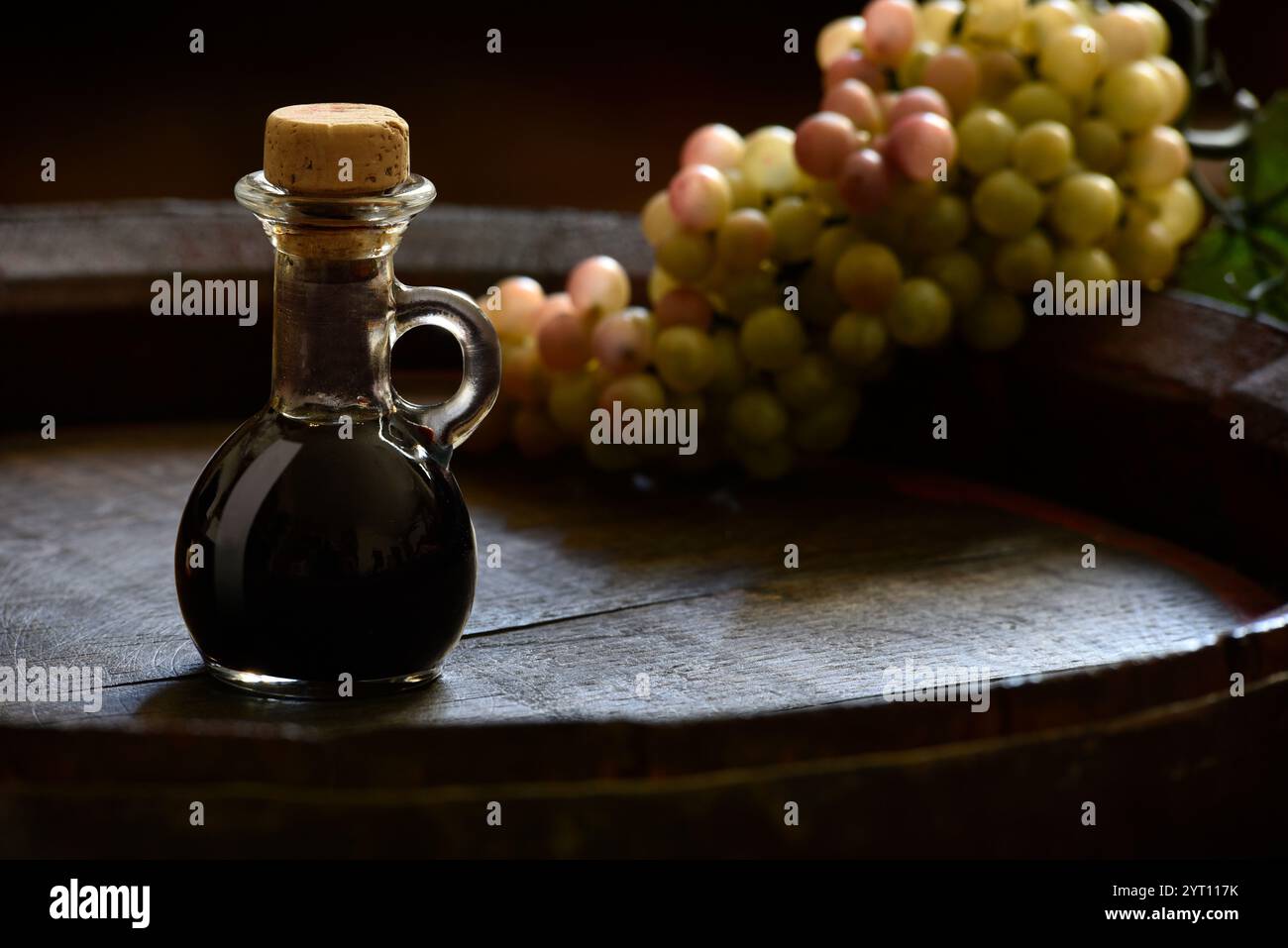 Traditional balsamic vinegar of Modena in a small bottle on a wooden ...
