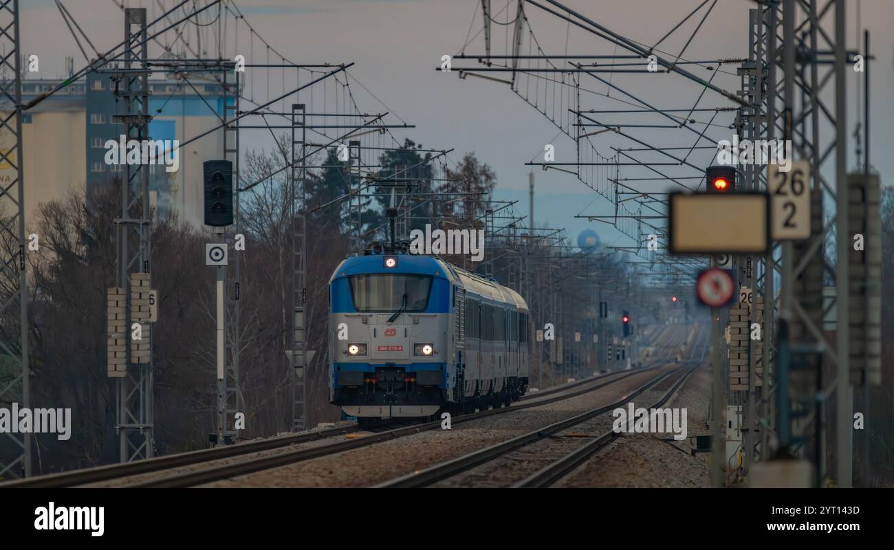 Fast passenger electric trains with sunset cloudy color near Neplachov ...