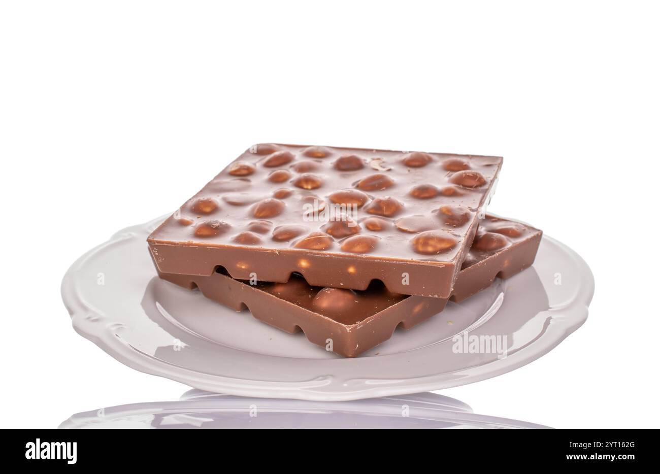 Two bars of dark chocolate with hazelnuts in a ceramic dish, close-up ...