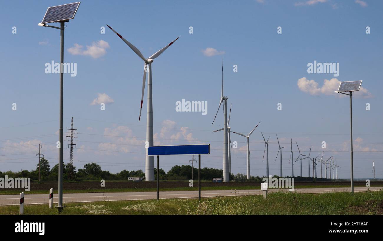 rural road and agricultural field with wind turbines and solar panels ...