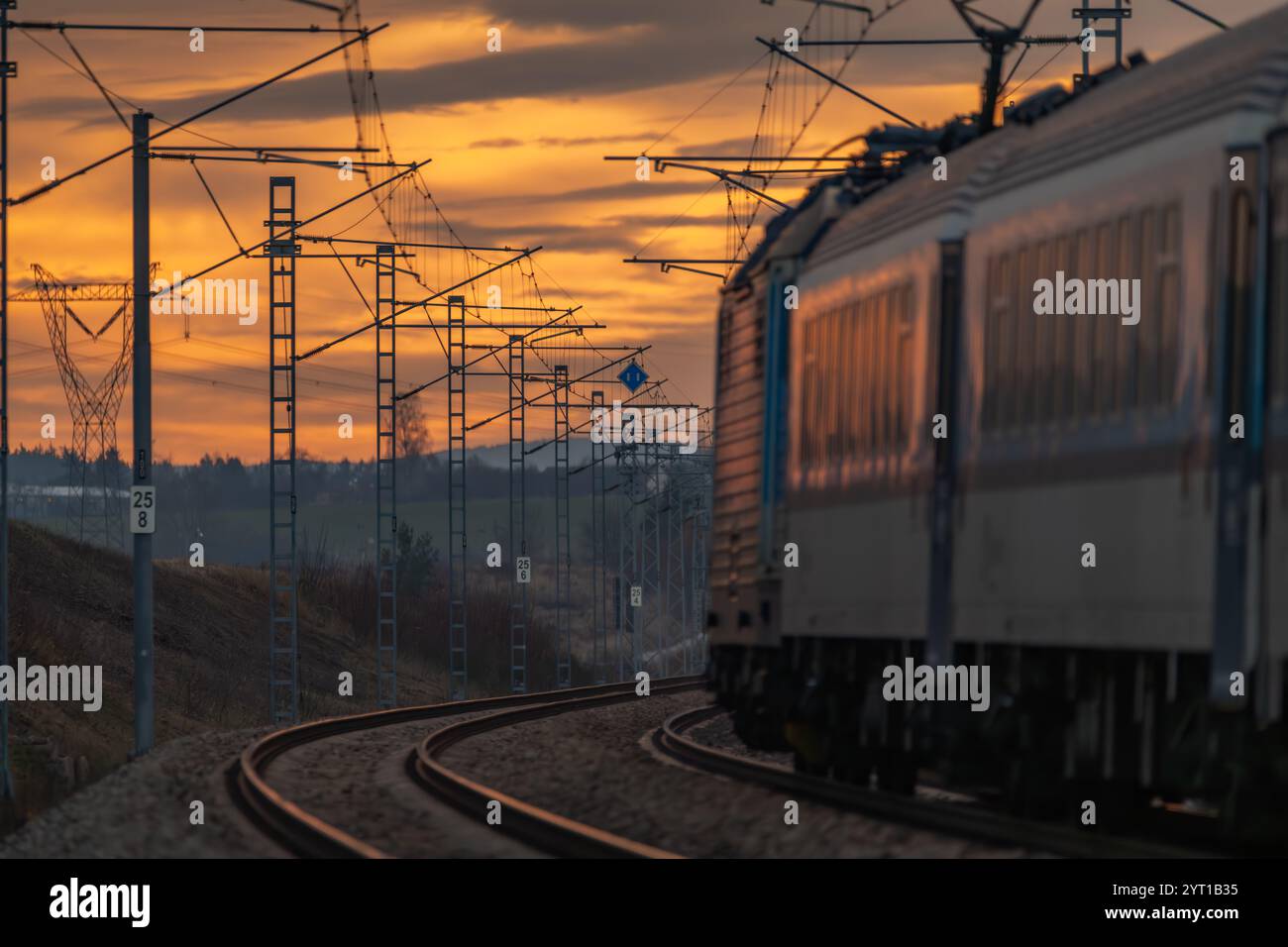 Fast passenger electric trains with sunset cloudy color near Neplachov ...