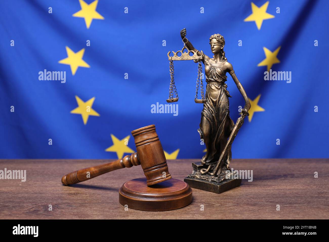 Figure of Lady Justice and judge's gavel on wooden table against ...