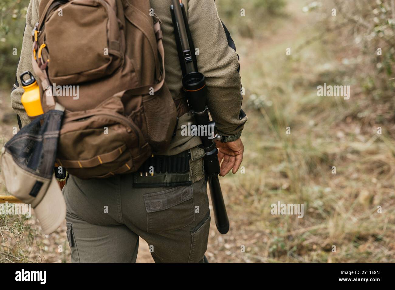 Hunter walking in the woods carrying a rifle and backpack Stock Photo ...