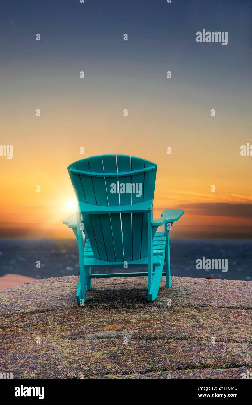 Empty Turquoise adirondack chair on a large boulder, catching the ...