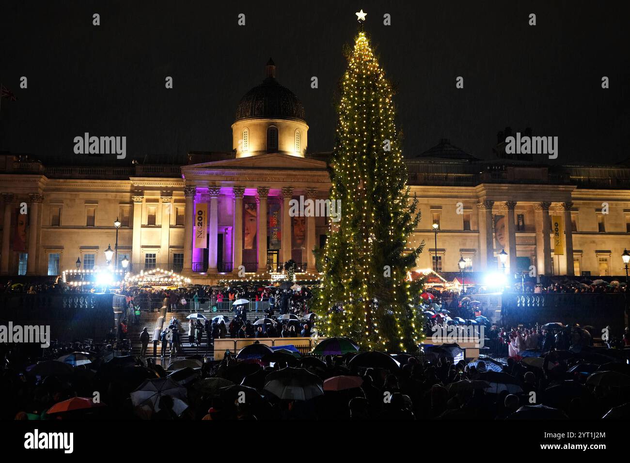 People watch the annual switching on of the Trafalgar Square Christmas Tree in London, Thursday ...