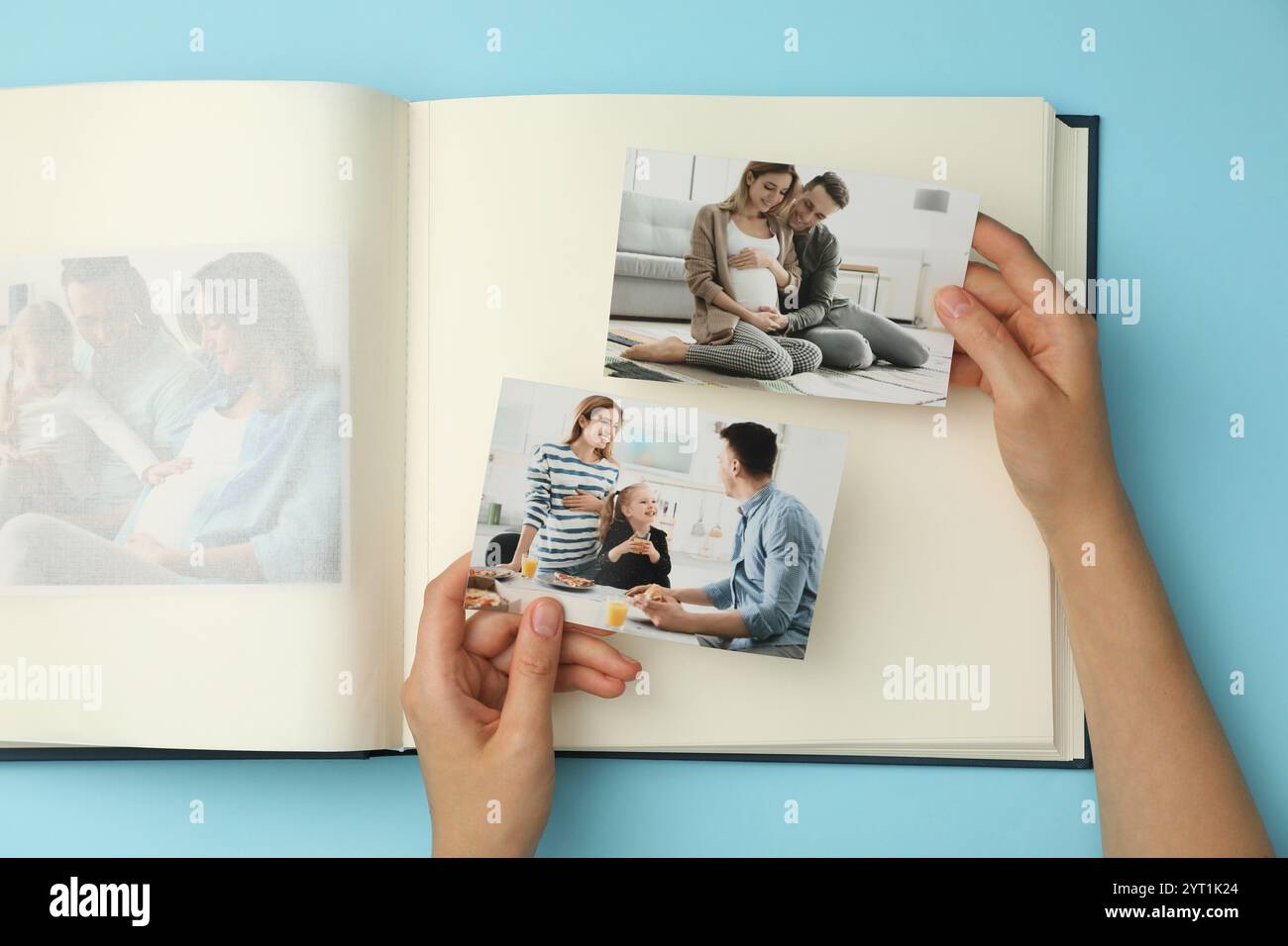 Woman with open photo album and different photos on light blue ...