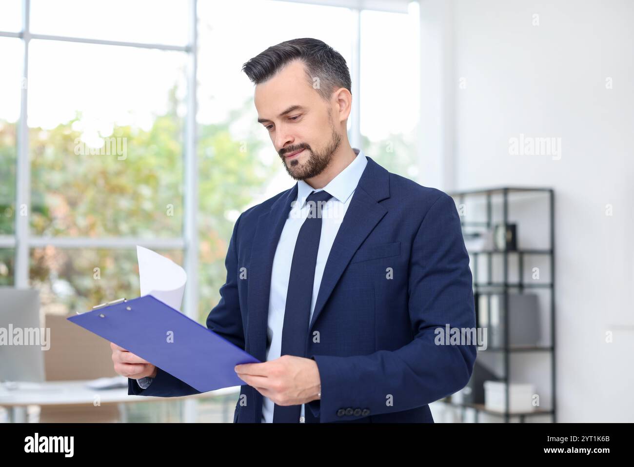 Handsome banker working with clipboard in office Stock Photo - Alamy
