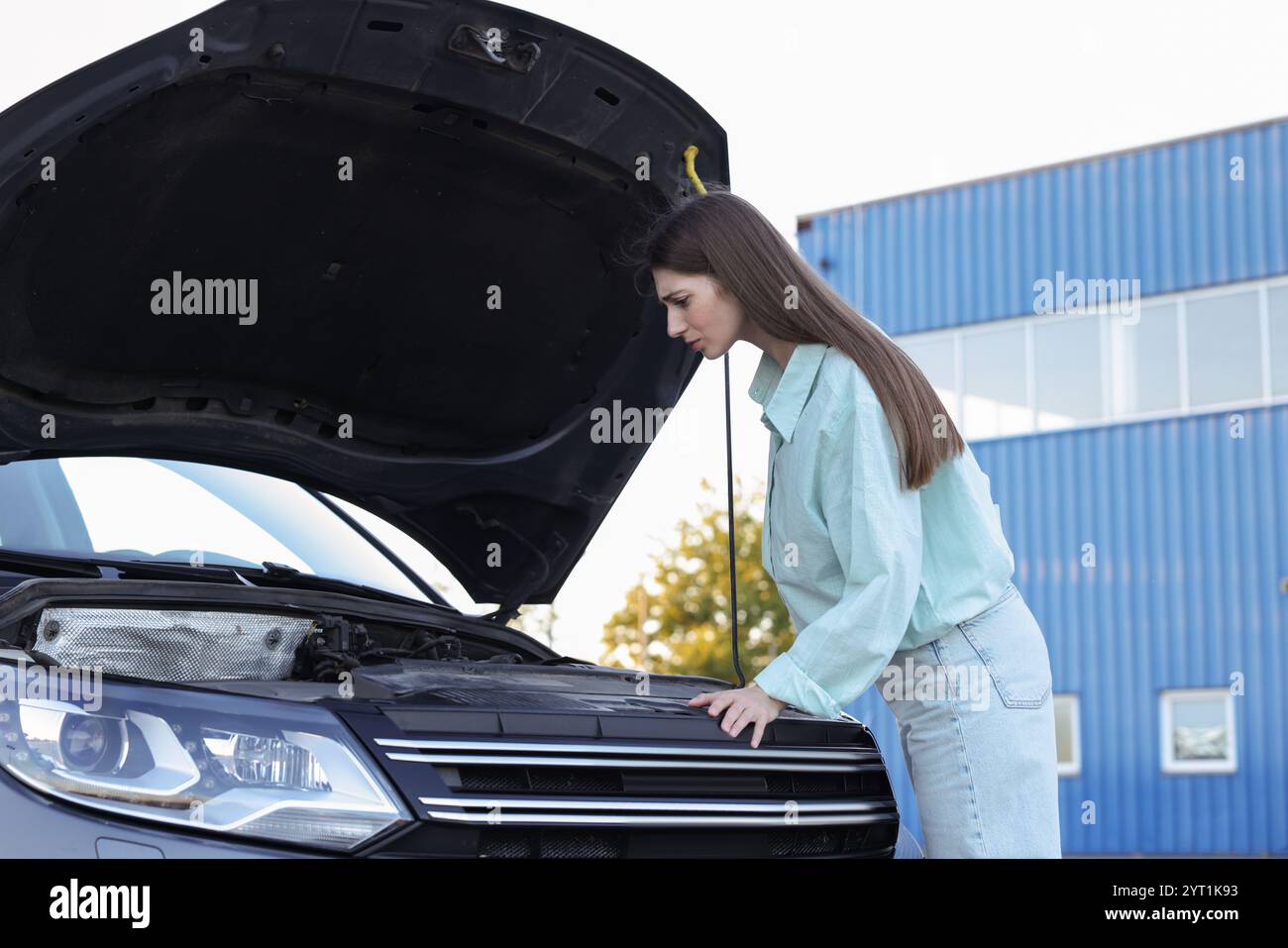 Woman looking under hood car hi-res stock photography and images - Alamy