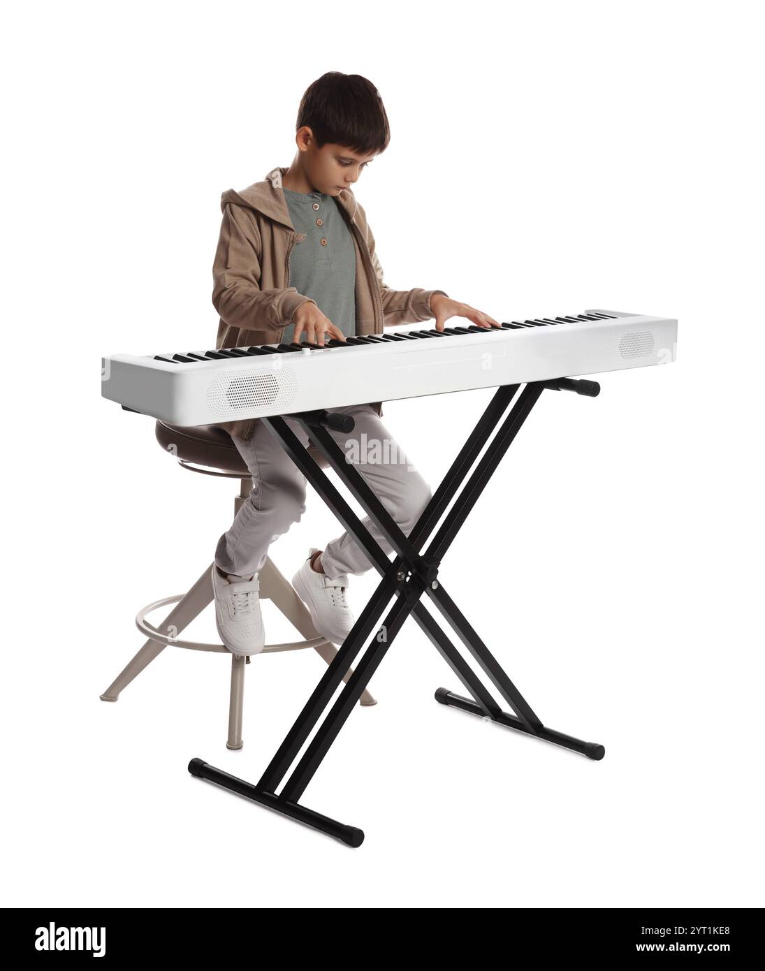 Cute boy playing synthesizer on white background Stock Photo - Alamy