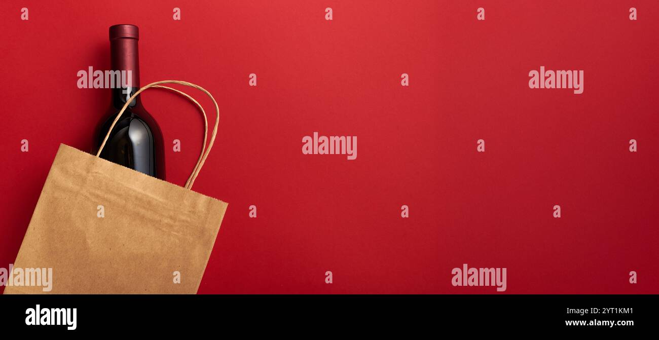 Paper bag with dark glass bottle of wine, alcohol present. Flat lay on ...