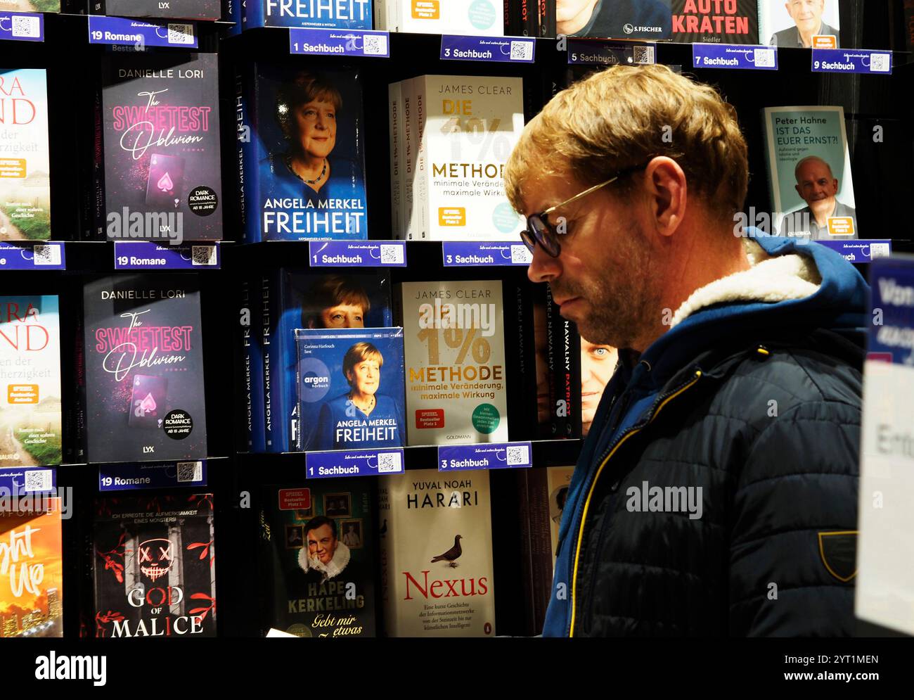 Germany, Passau - December 5, 2024: A man studies Ms. Merkel's book in ...
